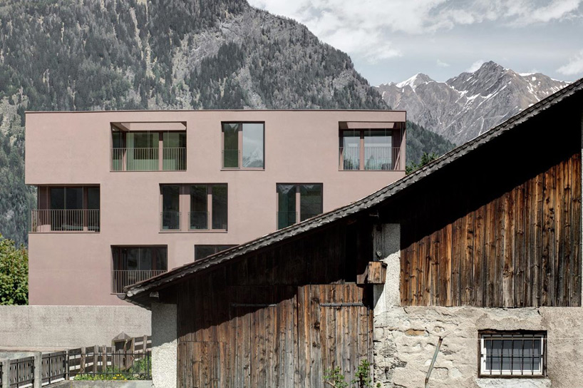 pedevilla sets pink homogenous apartment building against mountainous ...