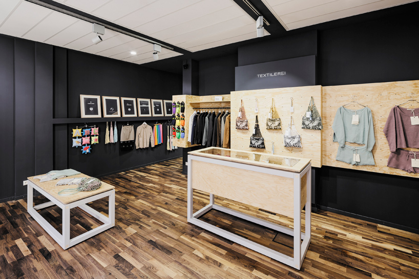 yalla yalla! adds a pine exhibition wall to a textile showroom