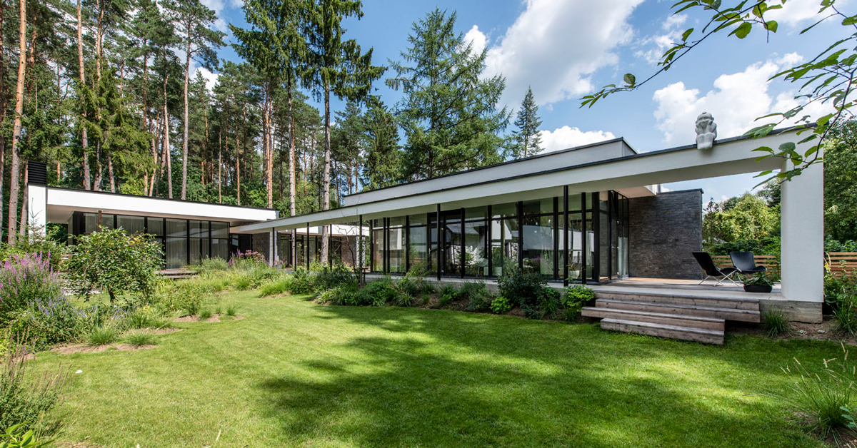 modernist house in lithuanian pine forest bridges a creek, by archLAB