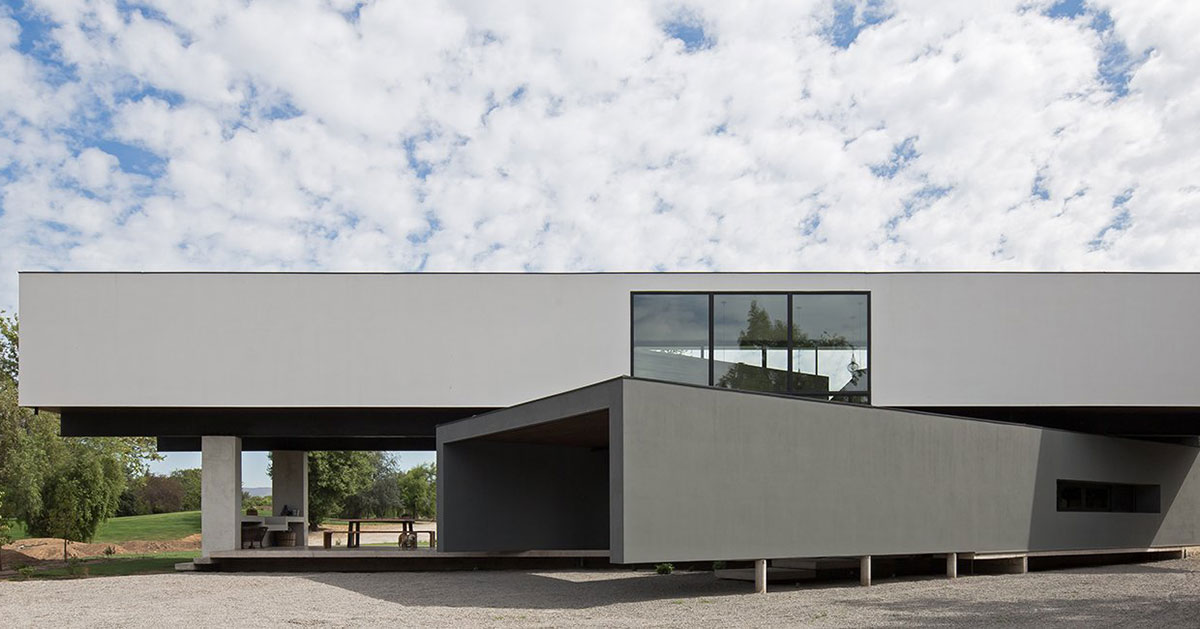 two overlapping elongated concrete volumes form the 'VH' family house ...