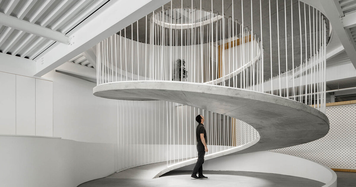 a spiral staircase connects paulo merlini's warehouse turned office in ...
