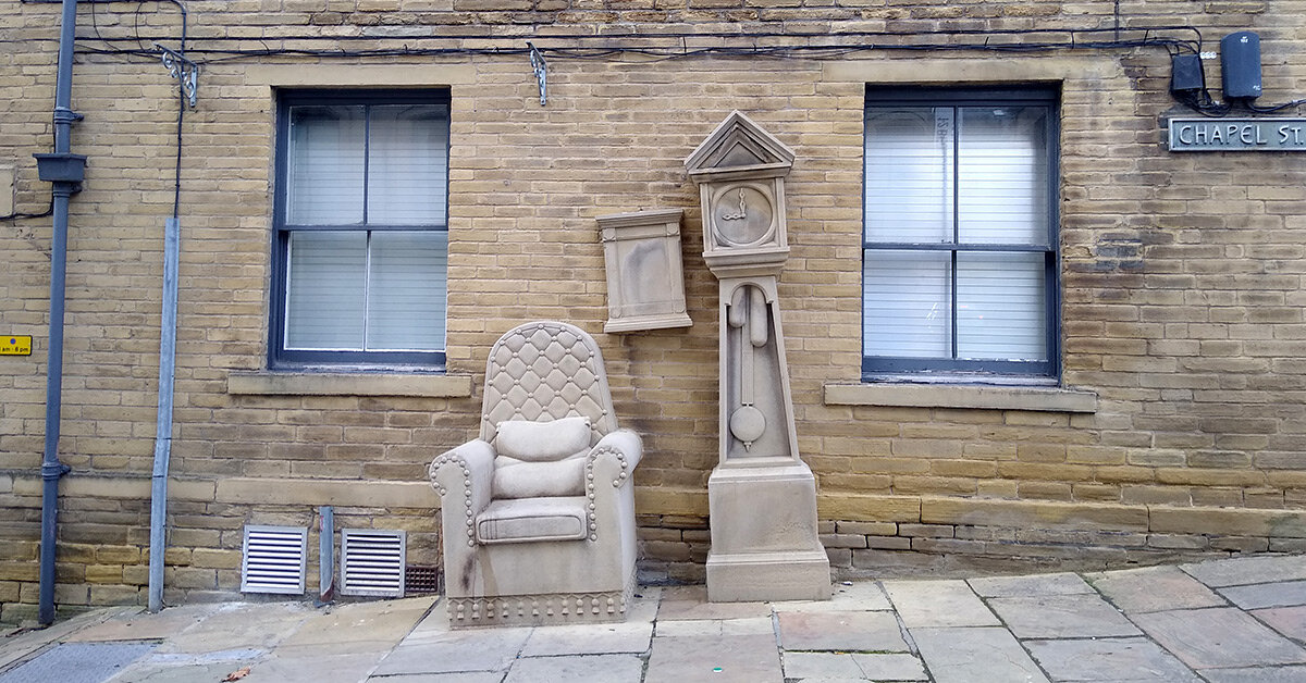 stone-carved grandad’s clock and chair by timothy shutter sit on a ...