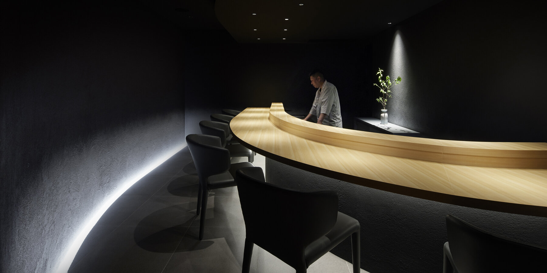 black-ink walls + dimmed lighting engulf 'sushi senju' in tokyo