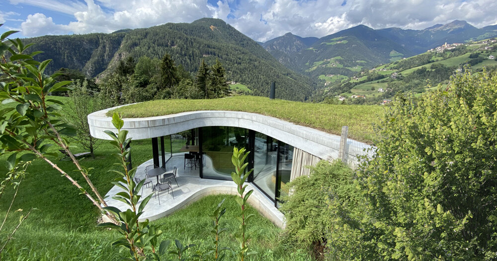 grassy 'freiform' house is embedded into the tyrolean landscape