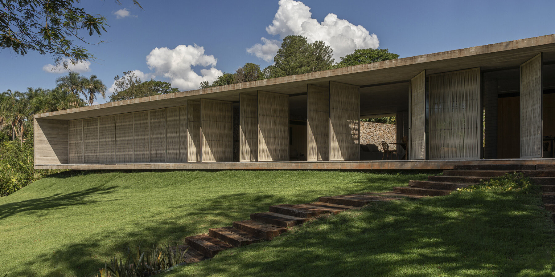 operable façade adds lightness to concrete house by mf+arquitetos