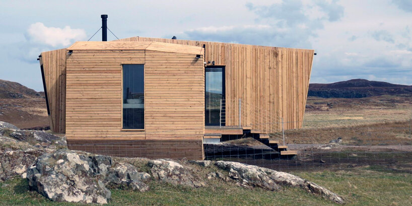 minimal wooden hut perches on a stony outcrop of the UK mainland