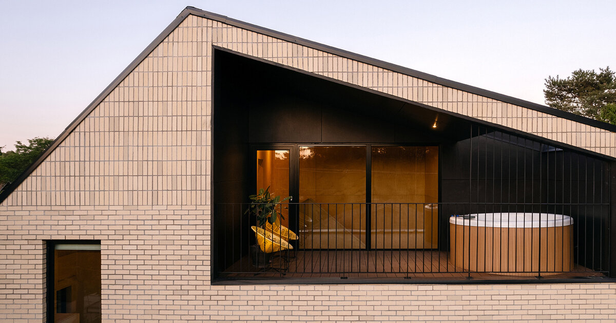 brick residence's sloping roof shields outdoor balcony in toronto