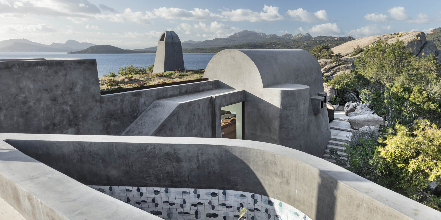 a house in sardinia by stefania stera rises as a monolith of granite & lava stone