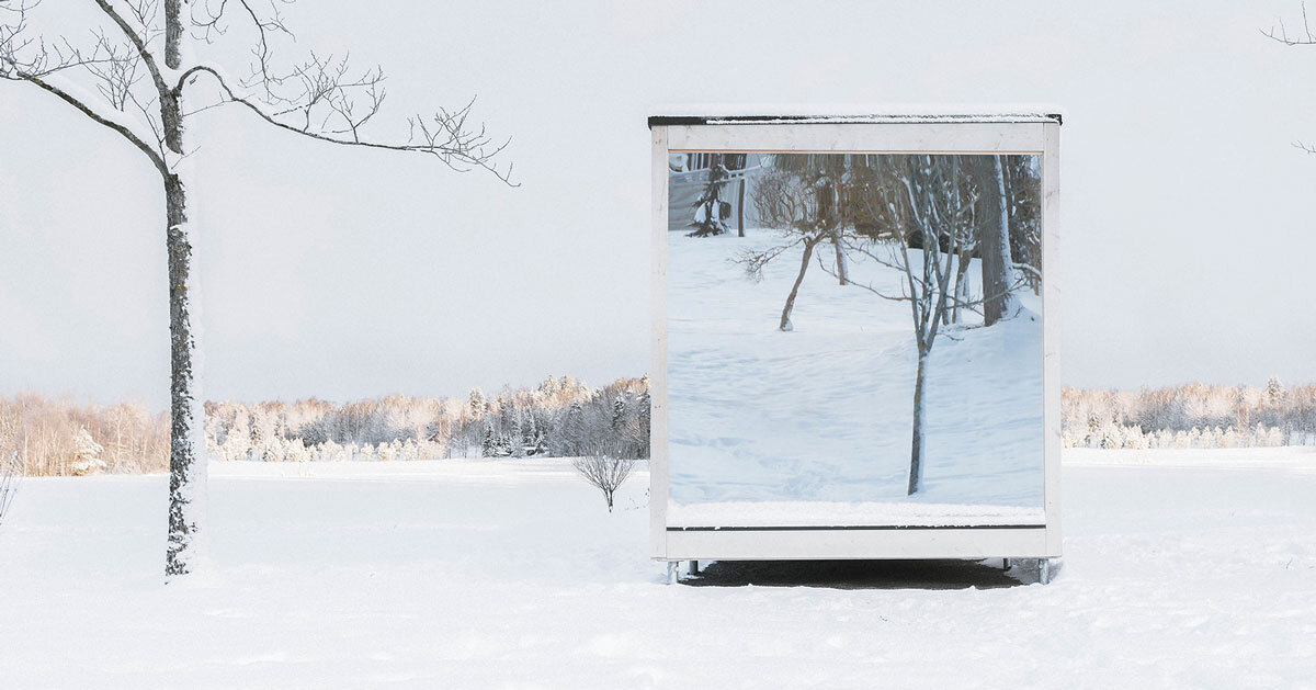 tyyni sauna's mirrored glazing reflects the snowy finnish landscape