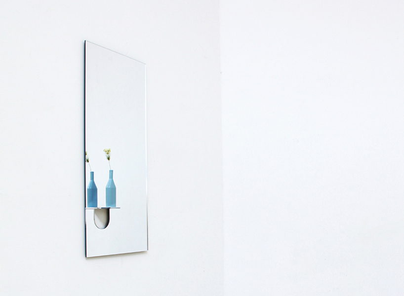 a U-shape cut into the mirror has been turned into a shelf to hold cups ...