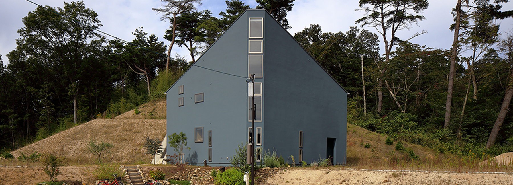 fujiwaramuro architects' triangular house in kobe sits atop hilly ...