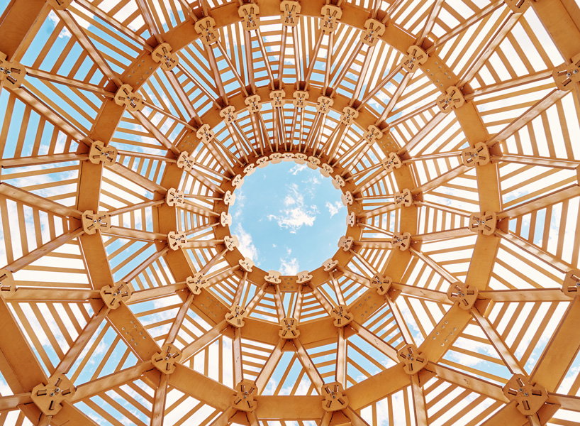 below the timber structure's striking oculus, the artist mixes natural ...