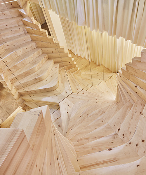 acme installs massive timber staircase with winding mirrors in its ...