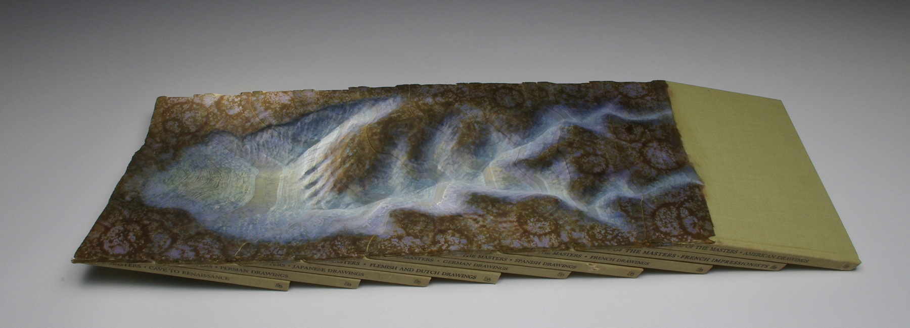 guy laramée deconstructs spiritual tomes into whimsical desert landscapes