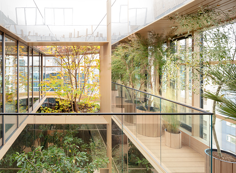 with wooden rails and pillars weaved into a grid on the façade, the ...