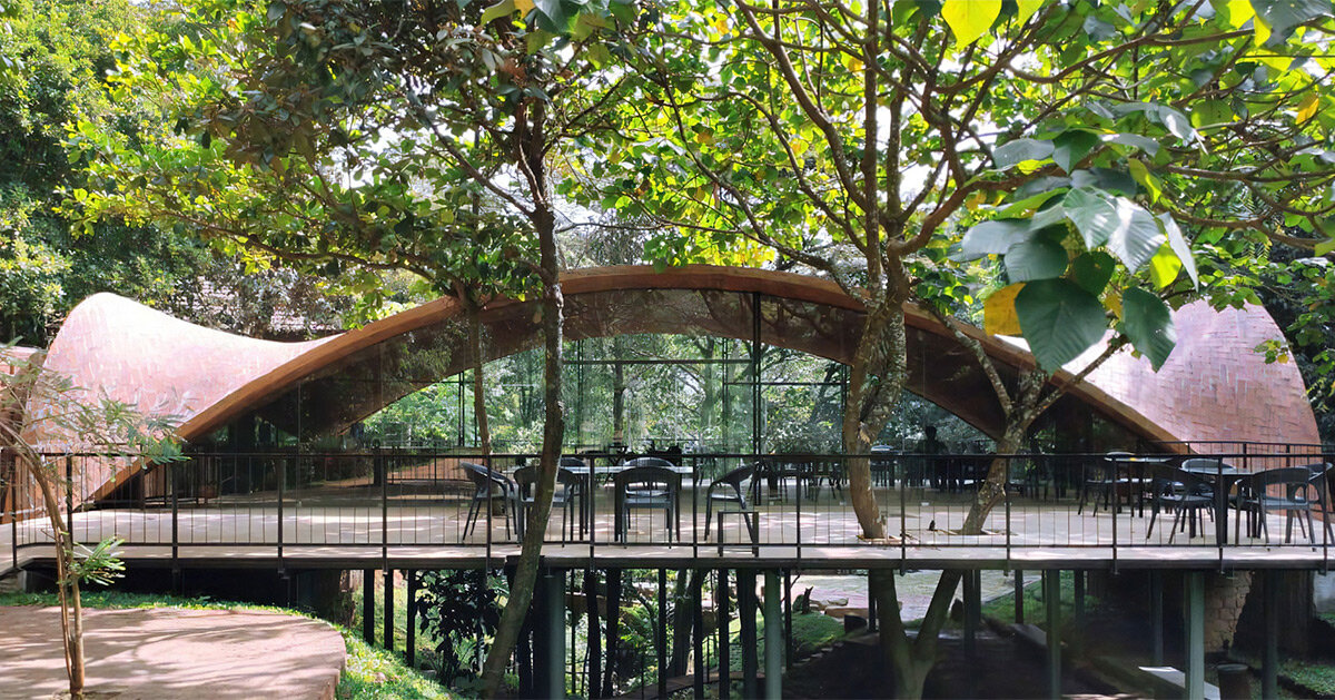Dining space with vaulted brick canopy perches above a serene lake in India