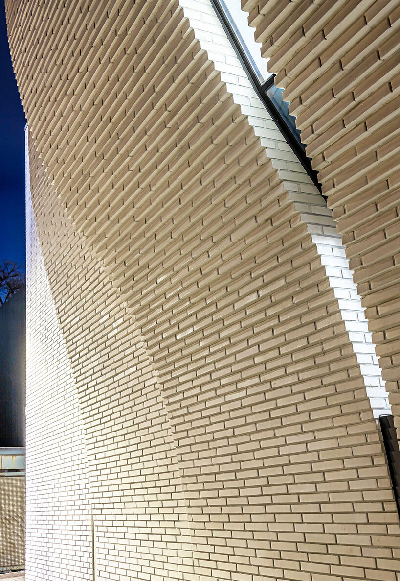 a curved brick wall ripples across LESS architects' office building ...