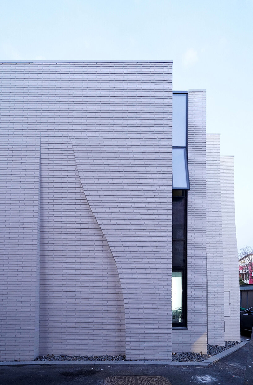 a curved brick wall ripples across LESS architects' office building ...