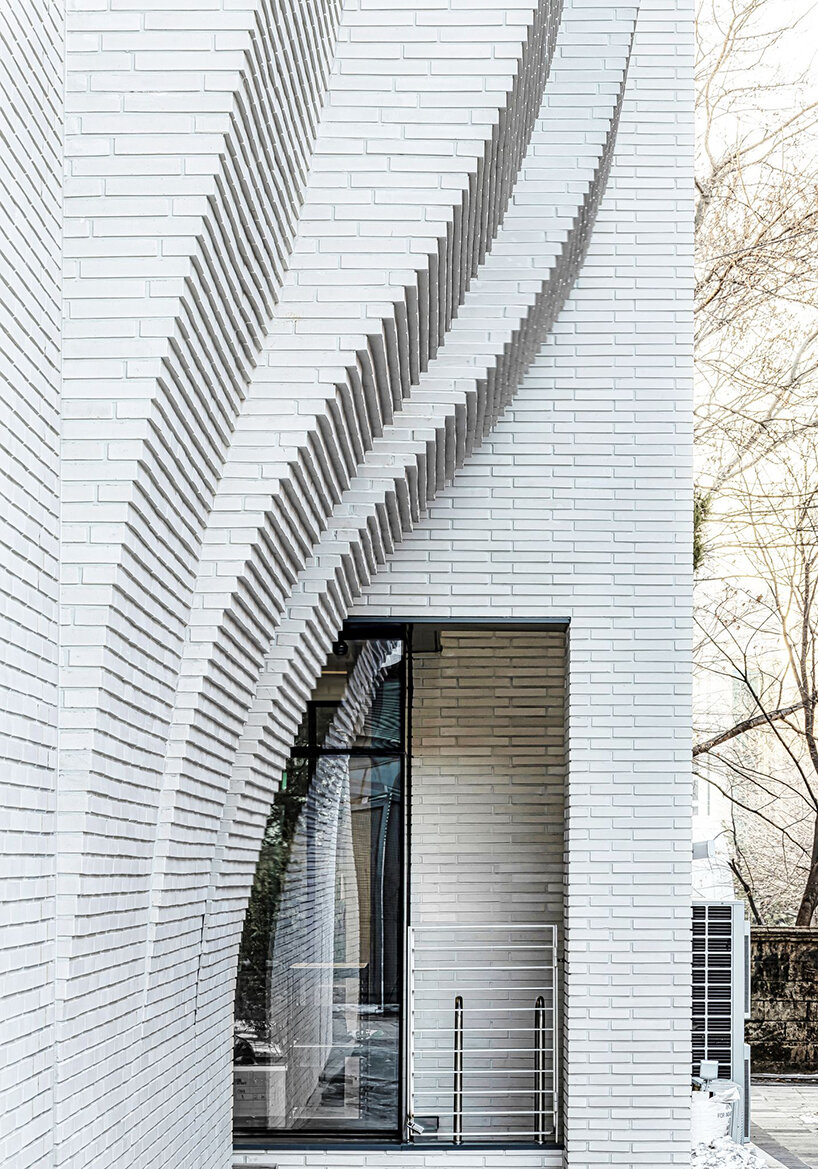 a curved brick wall ripples across LESS architects' office building ...