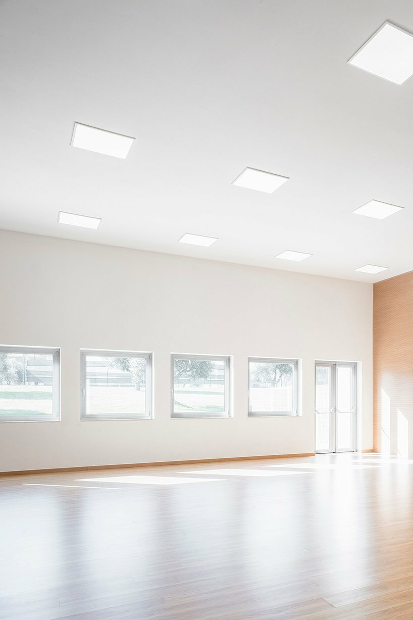 vibrant multipurpose room breathes new life into kindergarten in italy