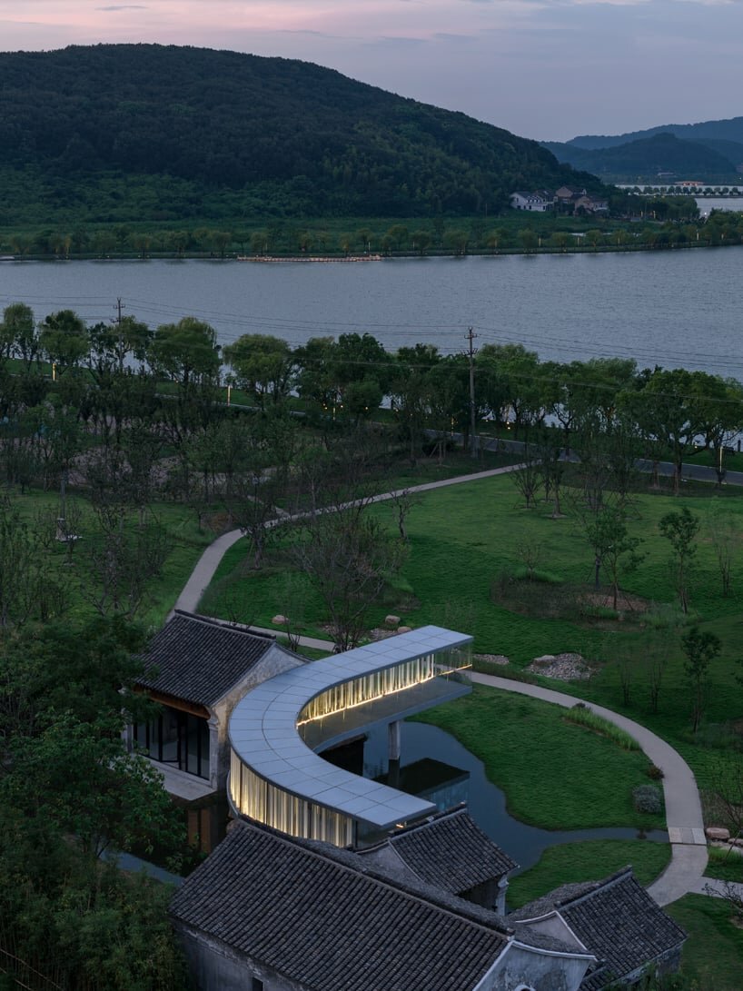 curved bridge corridor links two historic houses on chinese lakeside