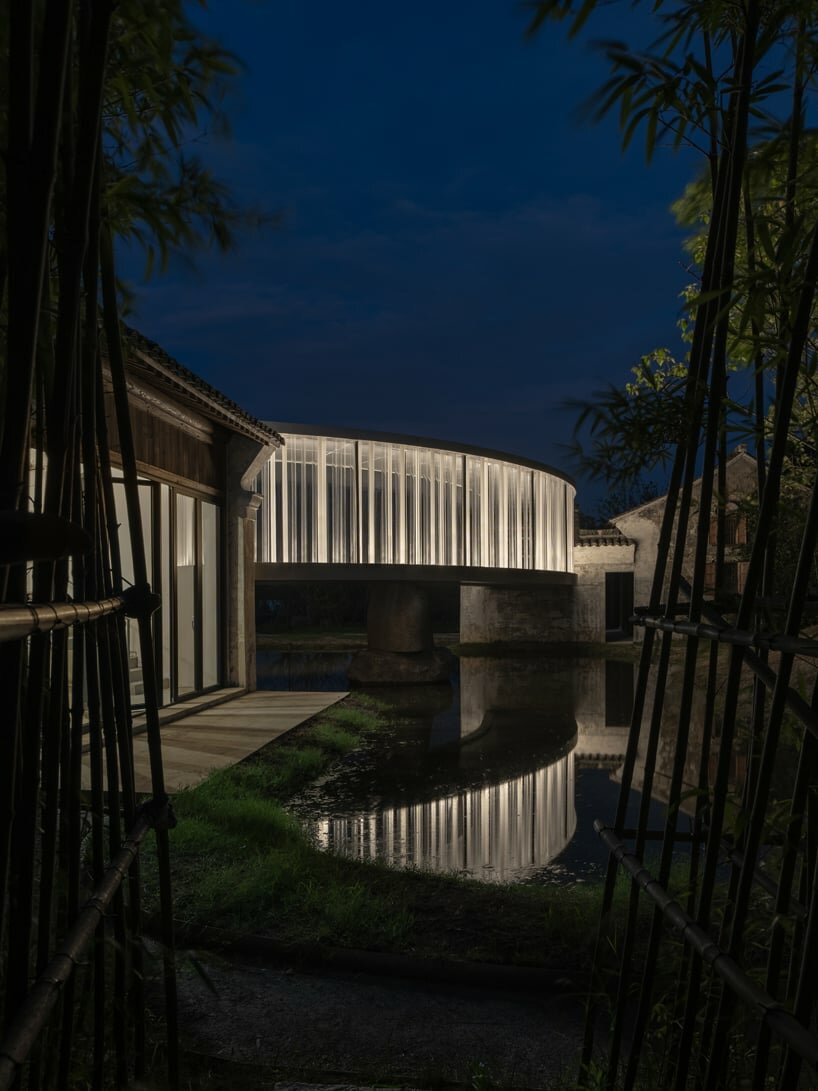 curved bridge corridor links two historic houses on chinese lakeside