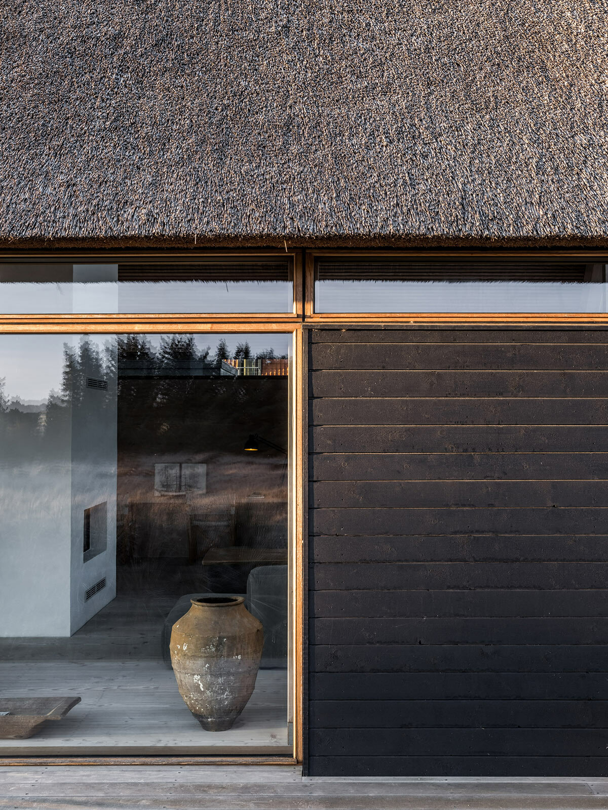 a thatched roof floats over PAX architects' skagen klitgård house