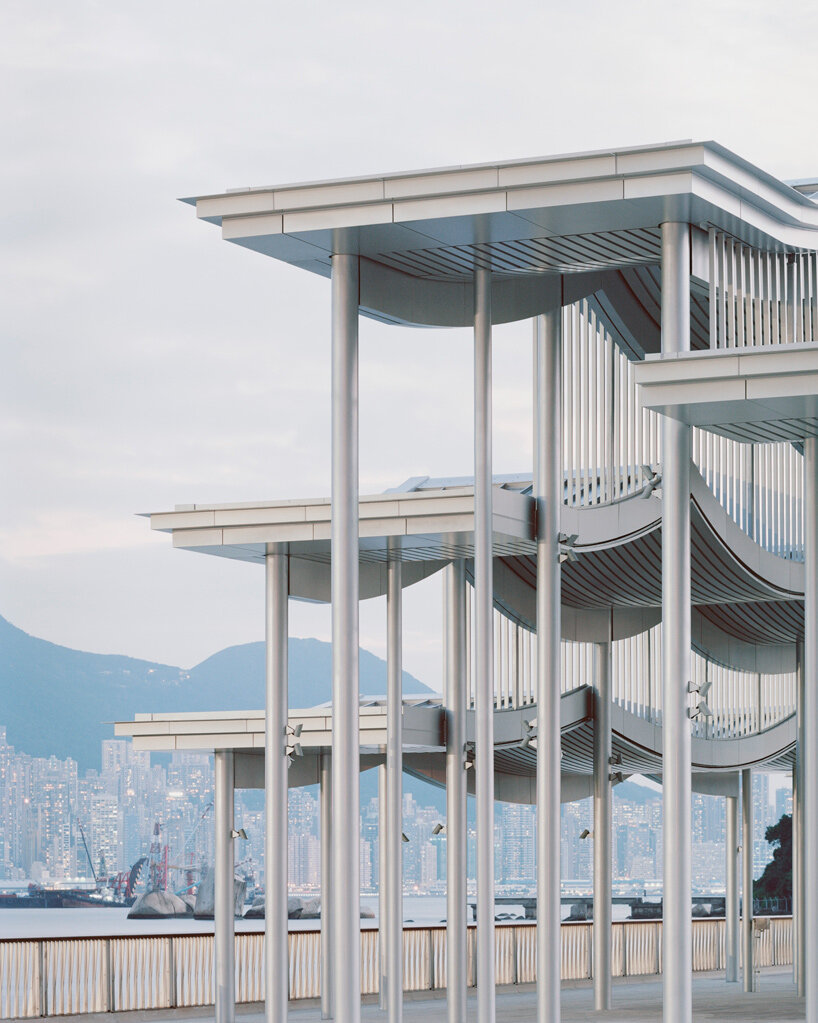 undulating canopy by new office works shelters waterfront promenade in hong kong