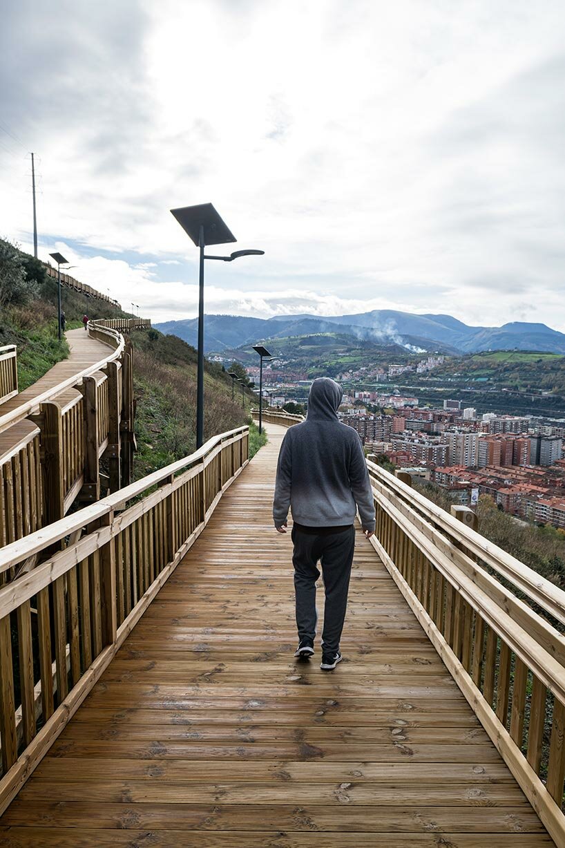 pedestrian wooden walkway on stilts traces hillside in bilbao