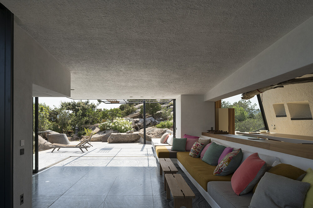 a house in sardinia by stefania stera rises as a monolith of granite & lava stone