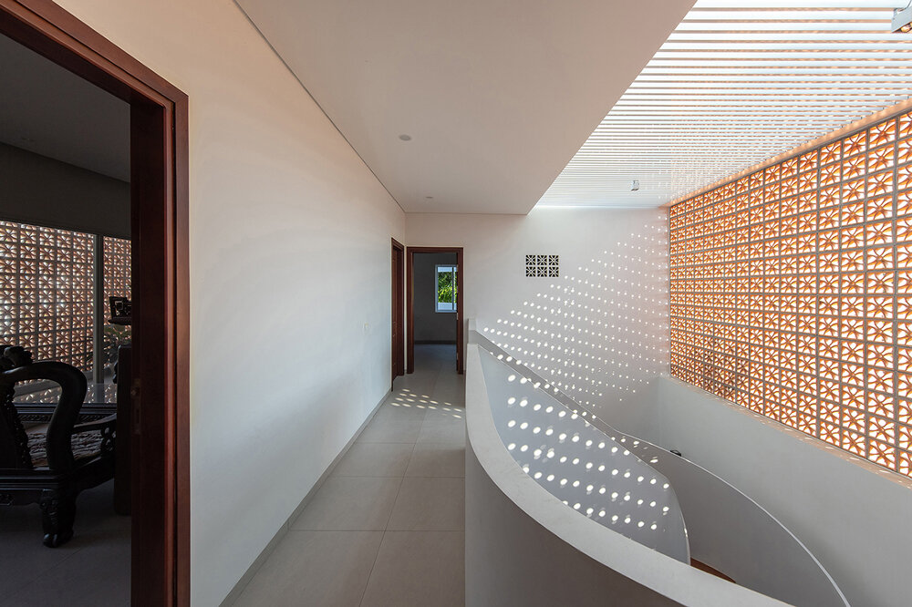 perforated double-skin brick facade shields grand house in vietnam