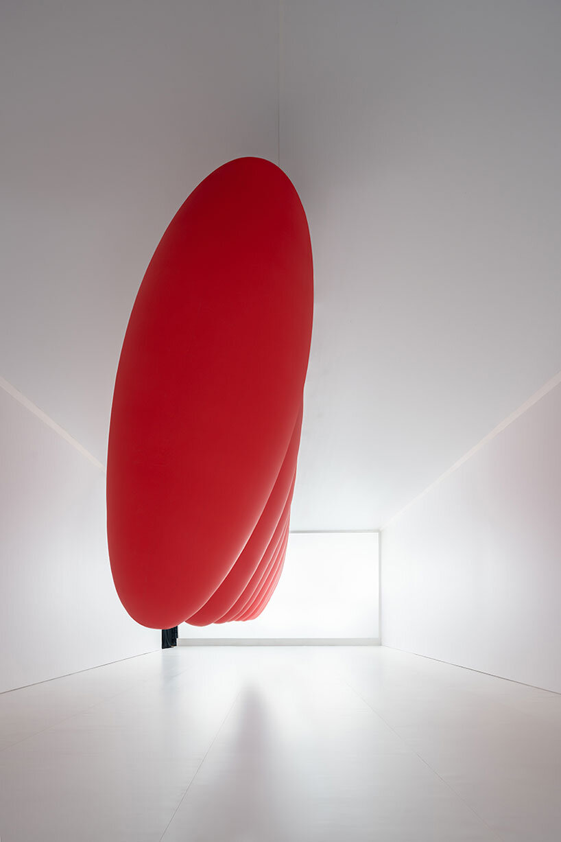 eight suspended red ovoids by SpY dance in pendular sequences